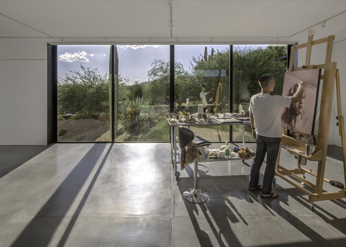 An Art Studio With Mirror-Like Glazing Floats Over a Desert Wash - Dwell