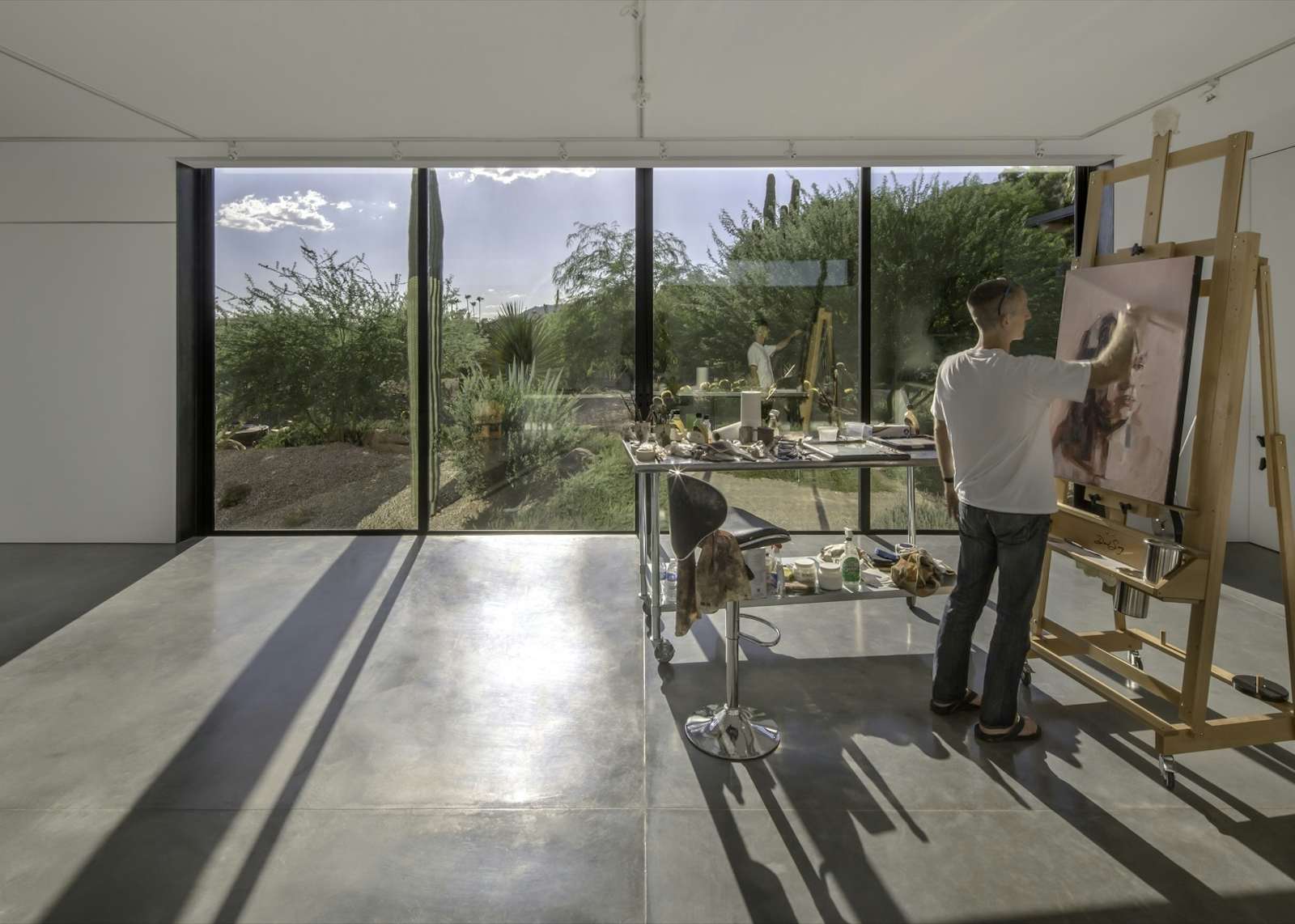 An Art Studio With Mirror-Like Glazing Floats Over a Desert Wash - Dwell