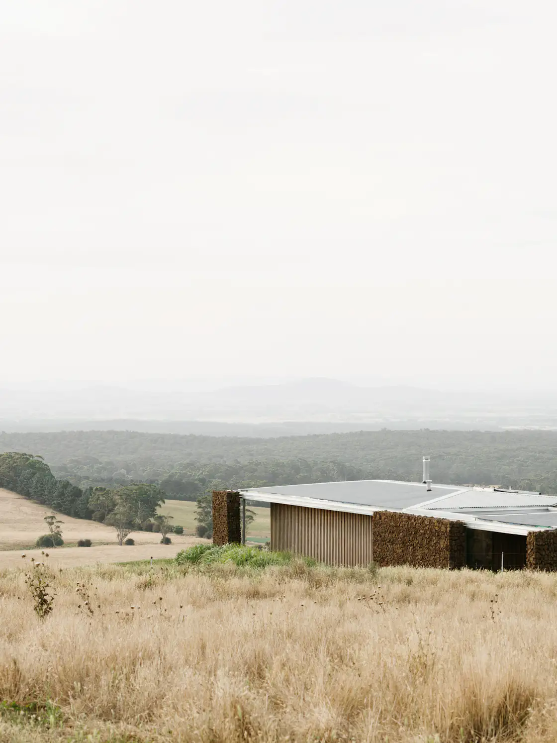 Photo 2 of 28 in Gabion Walls Made of Volcanic Rock Flank a Flat-Roofed ...
